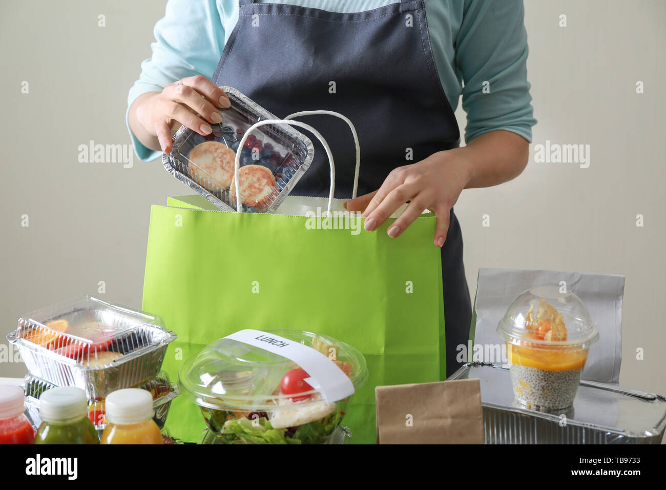 Worker of food delivery service packing order for customer Stock Photo ...