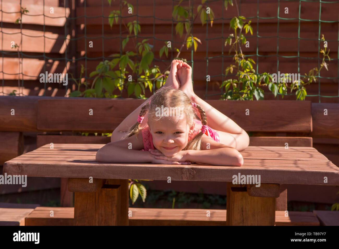 girl lying on the table in a wooden arbor Stock Photo - Alamy