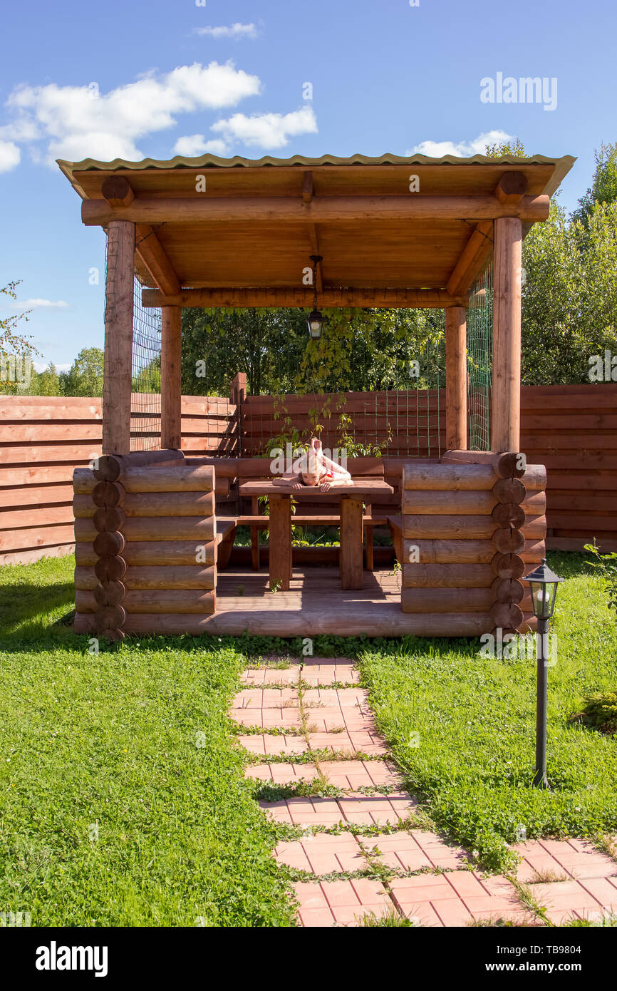 girl lying on the table in a wooden arbor Stock Photo - Alamy