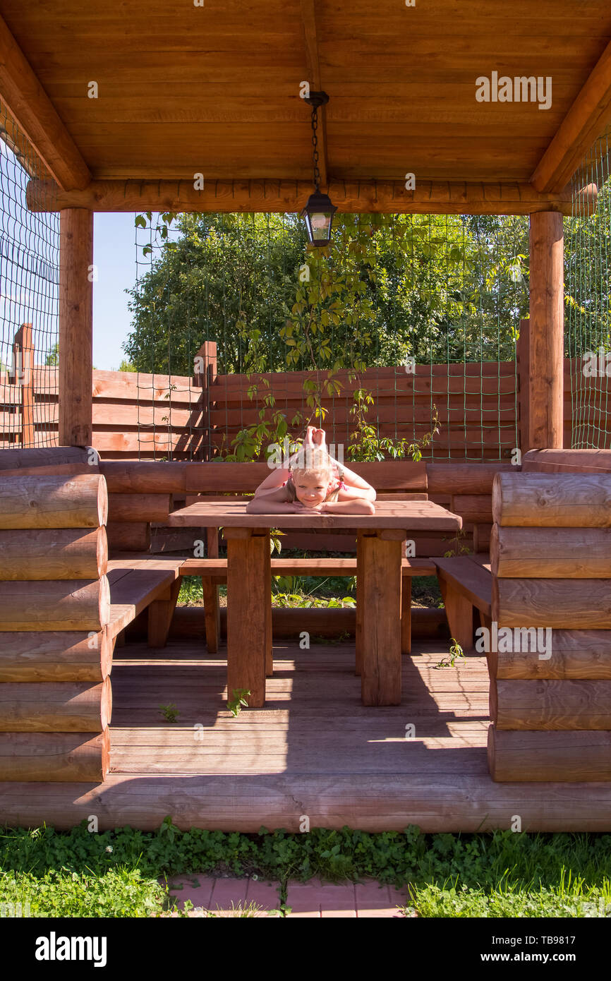 girl lying on the table in a wooden arbor Stock Photo - Alamy