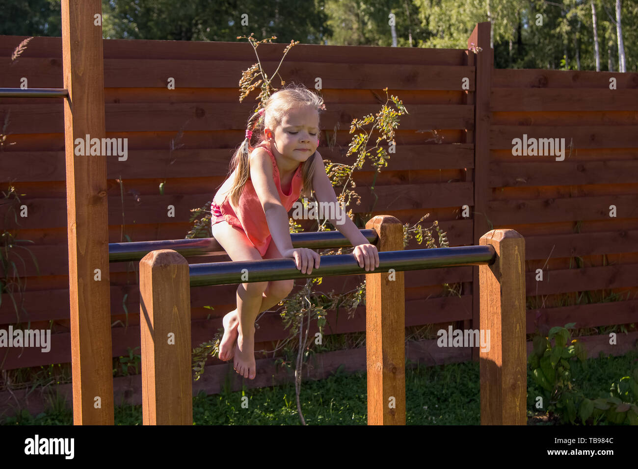 little girl sitting on the parallel bars Stock Photo - Alamy