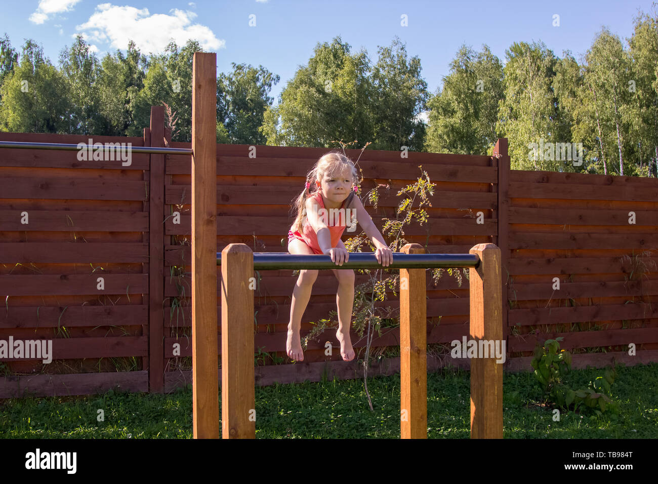 little girl sitting on the parallel bars Stock Photo - Alamy