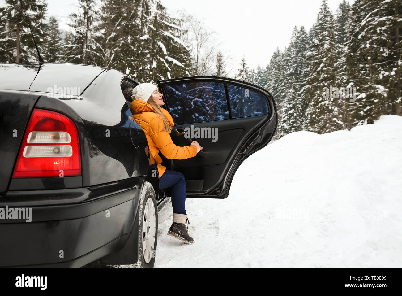 Young woman getting out of car at snowy winter resort Stock Photo - Alamy