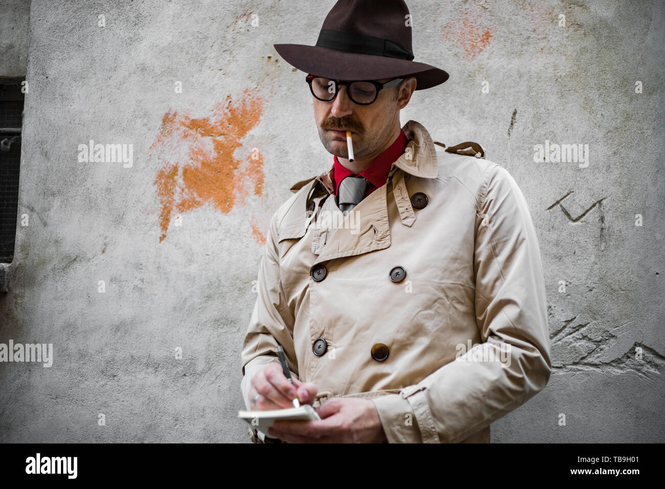 Detective taking notes in a ghetto Stock Photo - Alamy