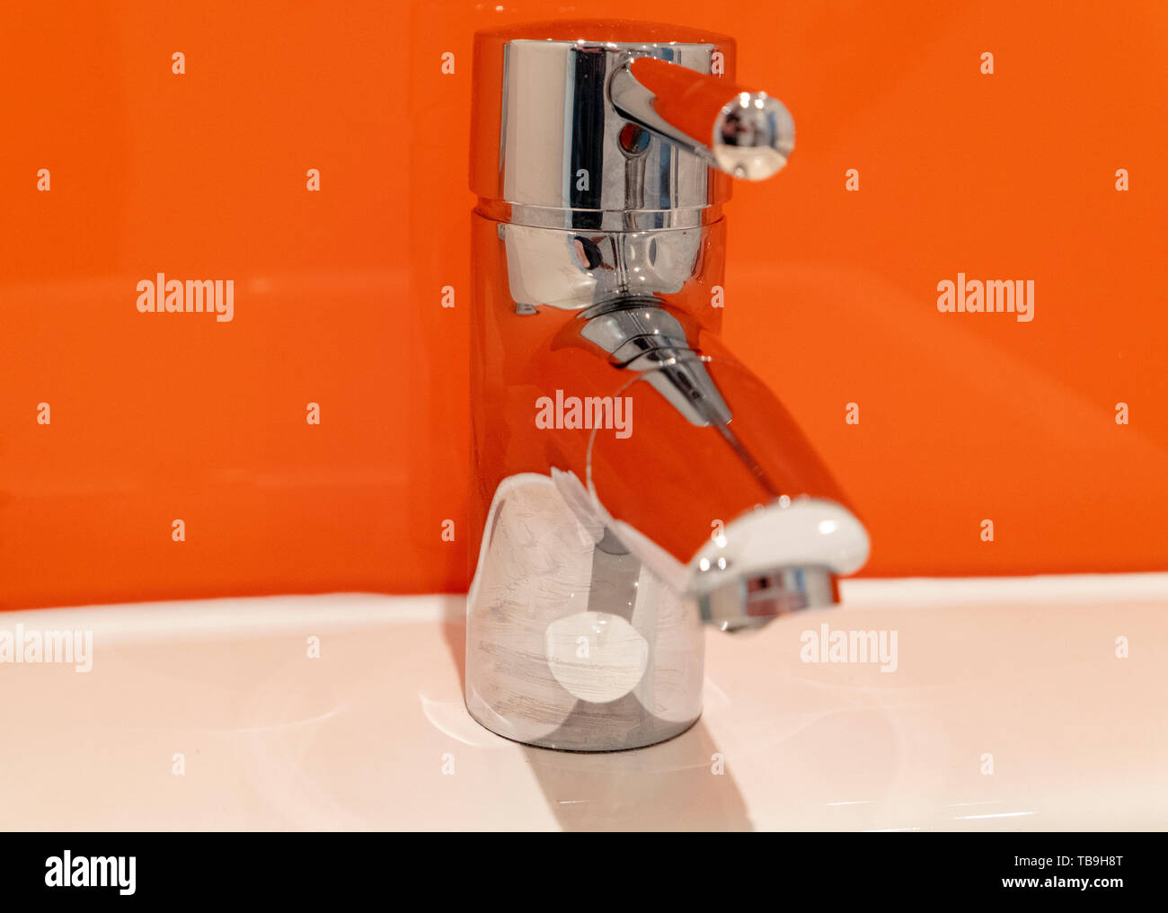 silver tap washbasin and orange background Stock Photo - Alamy