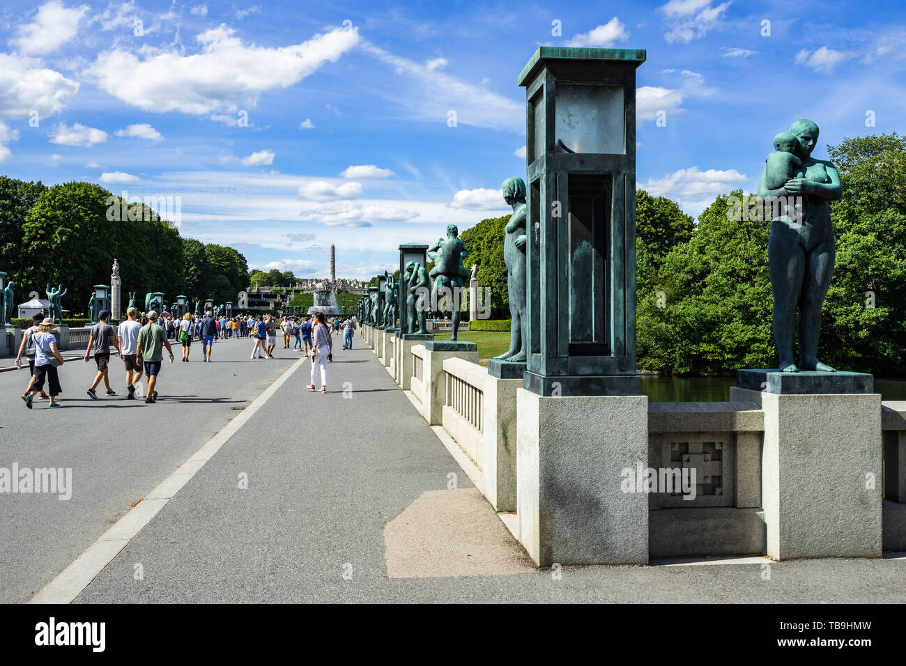 Tourists and locals strolling on the bridge of Frogner Park surrounded ...