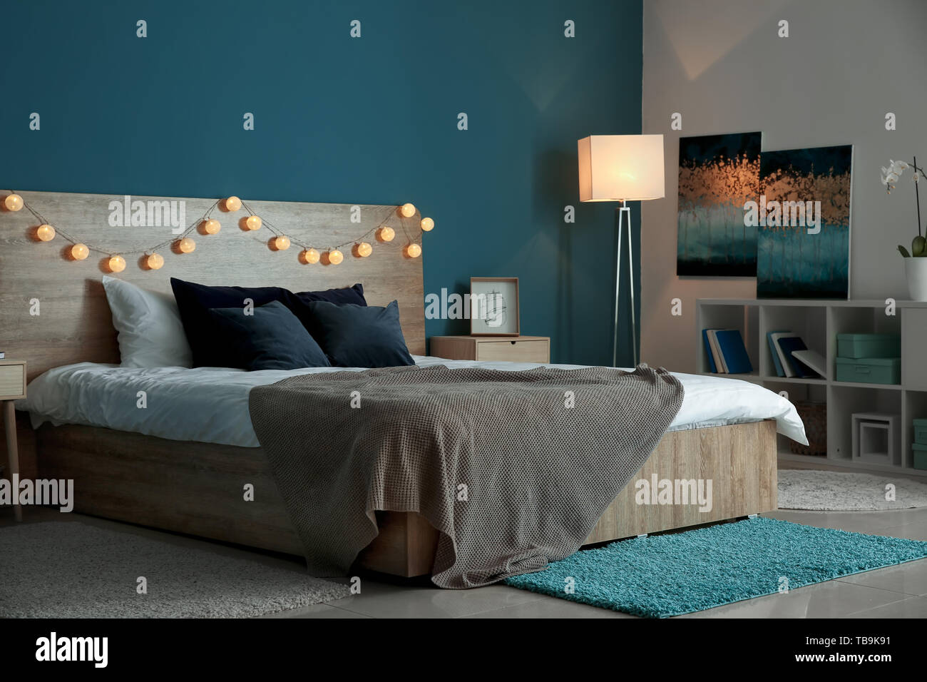 Big comfortable bed in stylish interior of room Stock Photo - Alamy