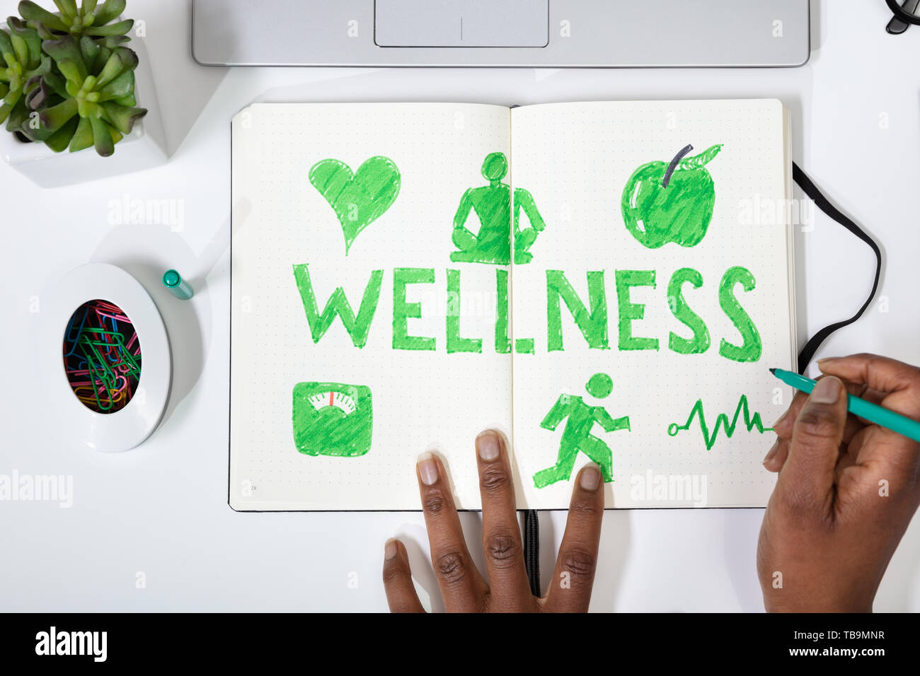 High Angle View Of A Human Hand Drawing Wellness Concept On Notebook ...
