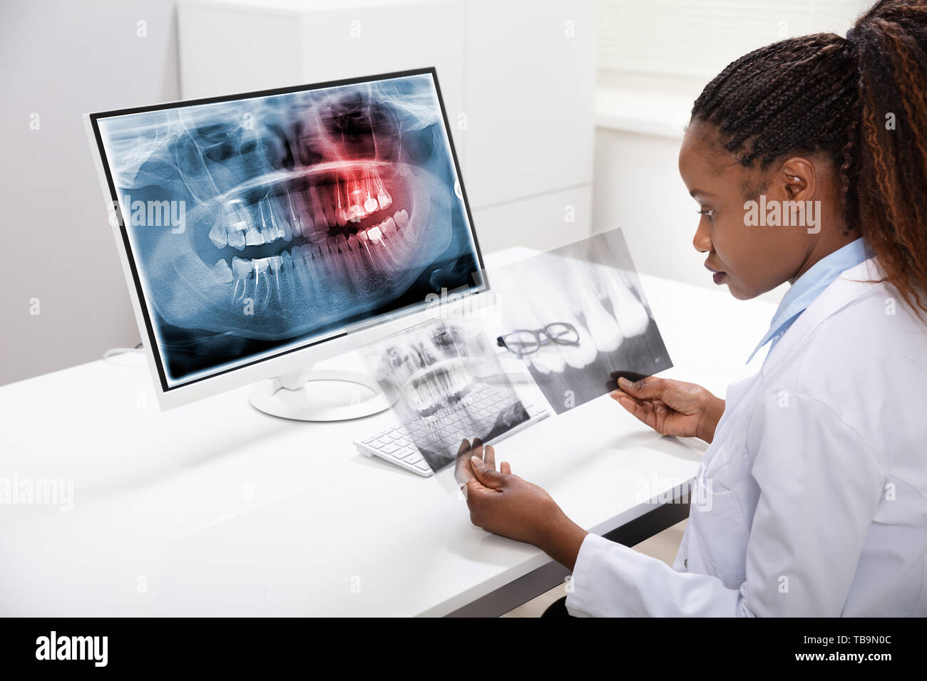 Female Dentist Examining Teeth X-ray On Computer Over Desk In Clinic ...