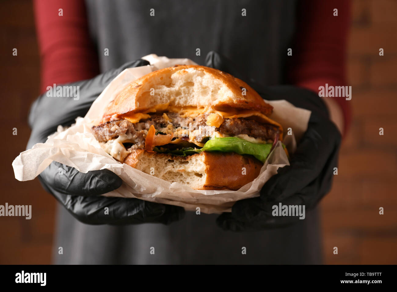 Woman holding tasty bitten burger, closeup Stock Photo - Alamy