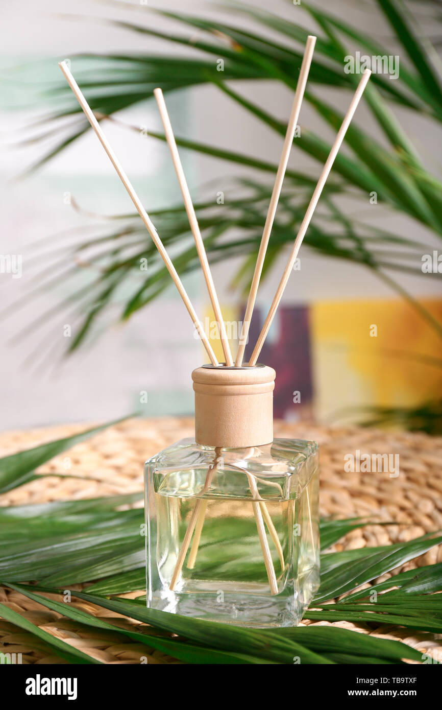 Reed diffuser and tropical leaves in room Stock Photo - Alamy