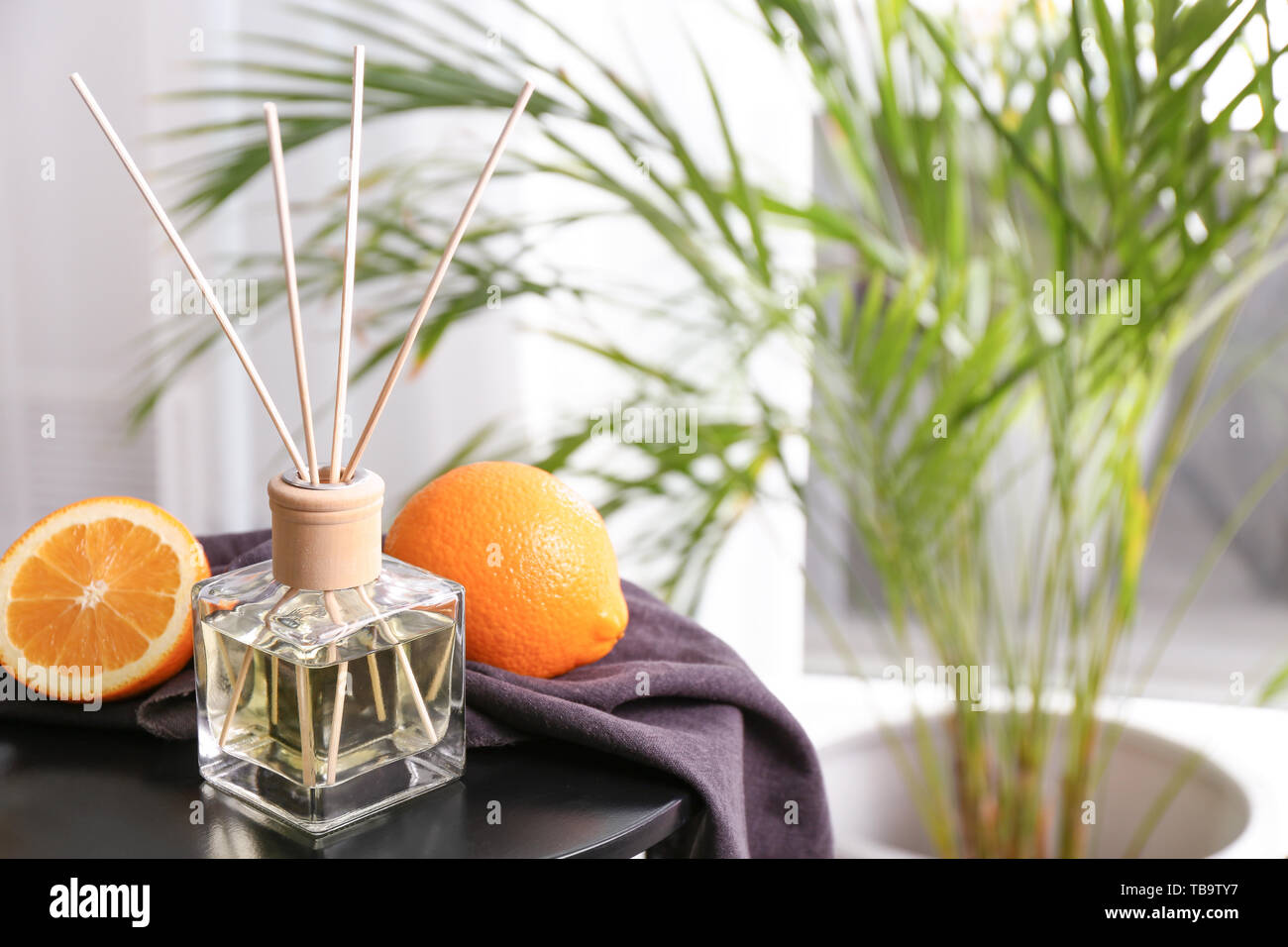 Citrus reed diffuser on table in room Stock Photo - Alamy