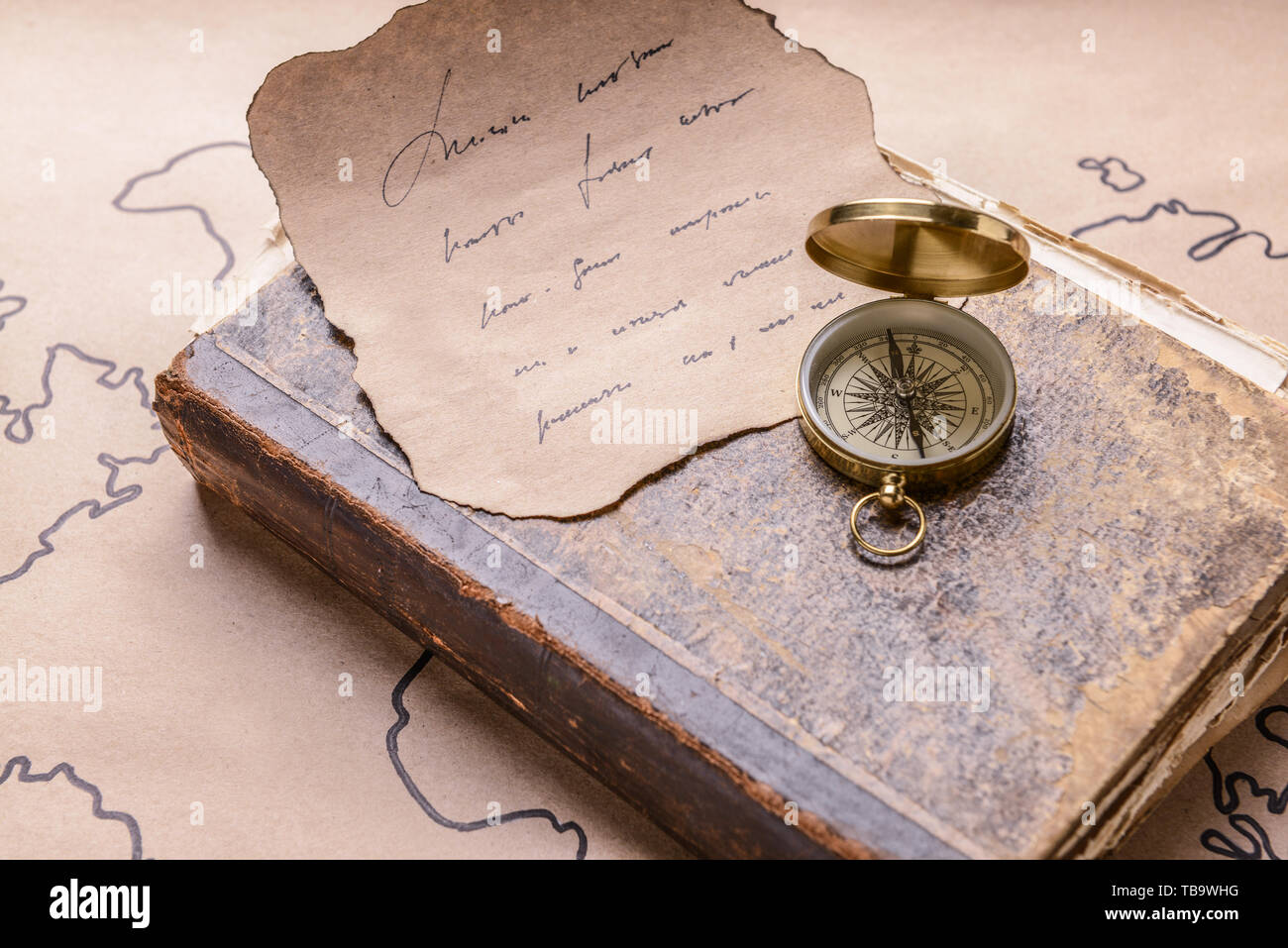 Old book, compass and paper sheet on world map. Travel concept Stock ...