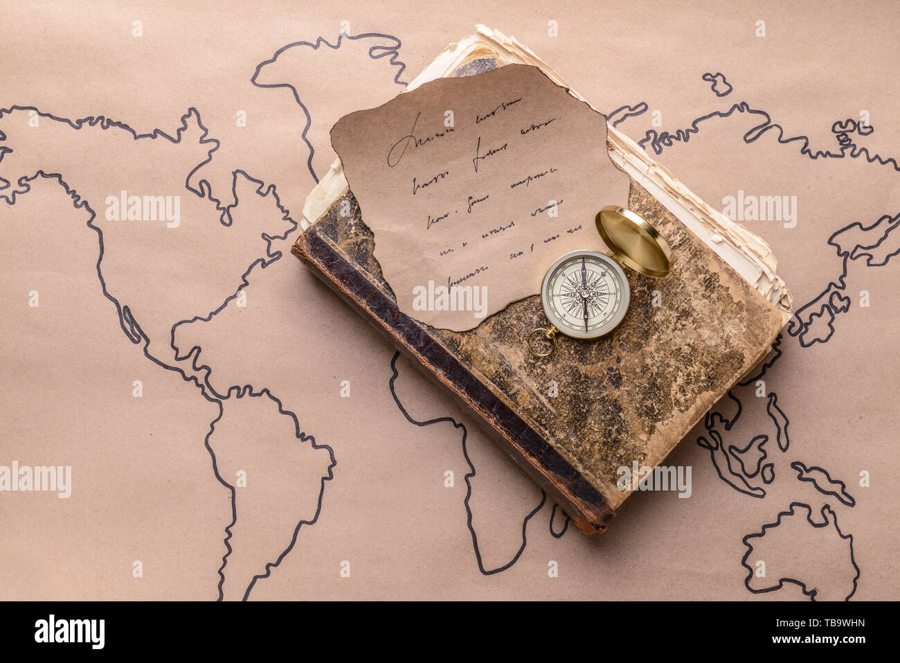Old book, compass and paper sheet on world map. Travel concept Stock ...