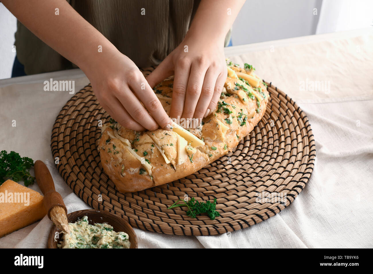 Woman making tasty garlic bread in kitchen Stock Photo - Alamy