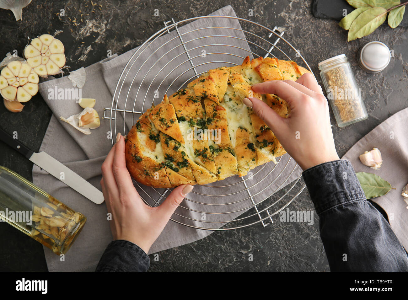 Woman eating tasty garlic bread in kitchen Stock Photo - Alamy