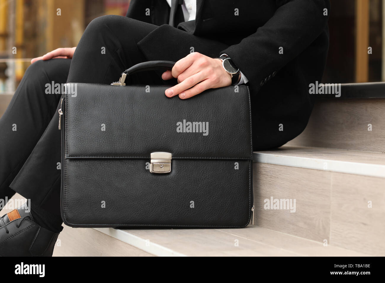 Businessman with stylish briefcase sitting on stairs outdoors Stock ...