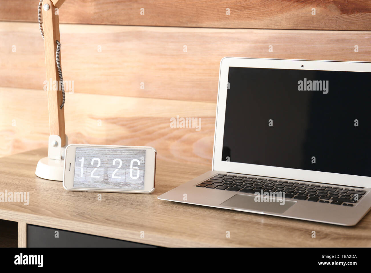 Laptop and mobile phone with running clock application on table Stock ...