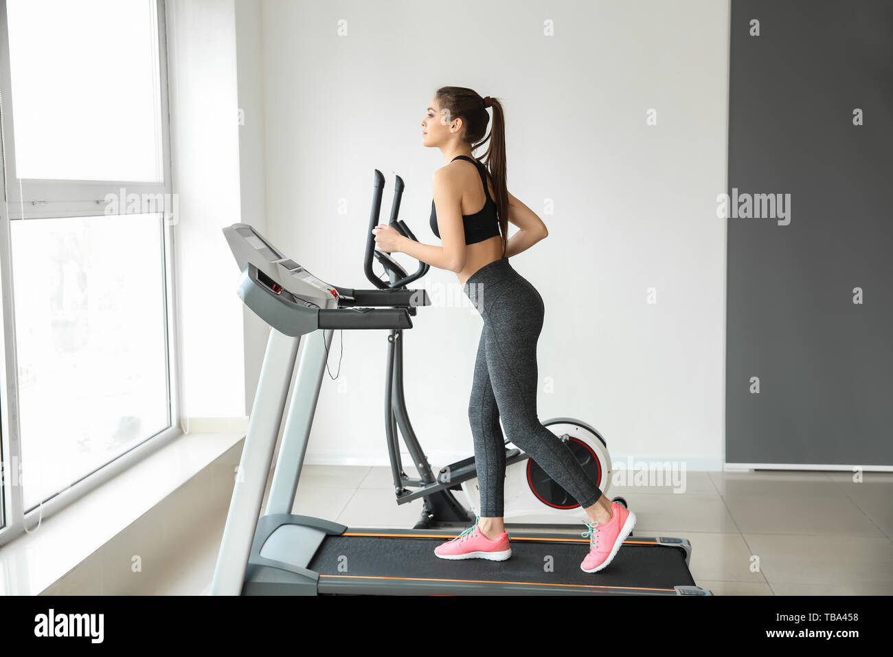 Sporty young woman on treadmill in gym Stock Photo - Alamy