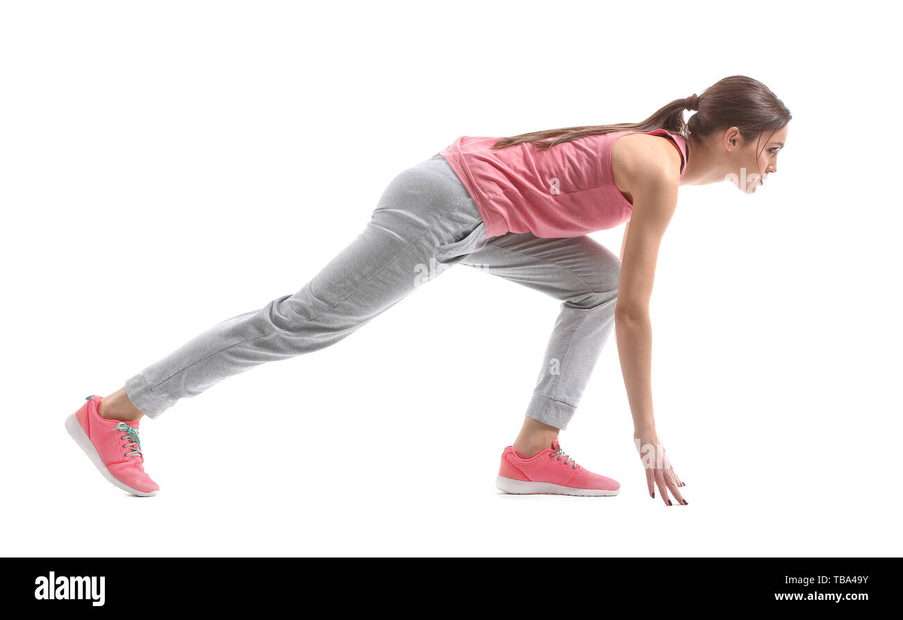 Sporty young woman in crouch start position against white background ...