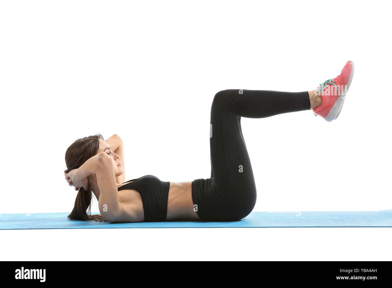 Sporty young woman doing crunches against white background Stock Photo ...