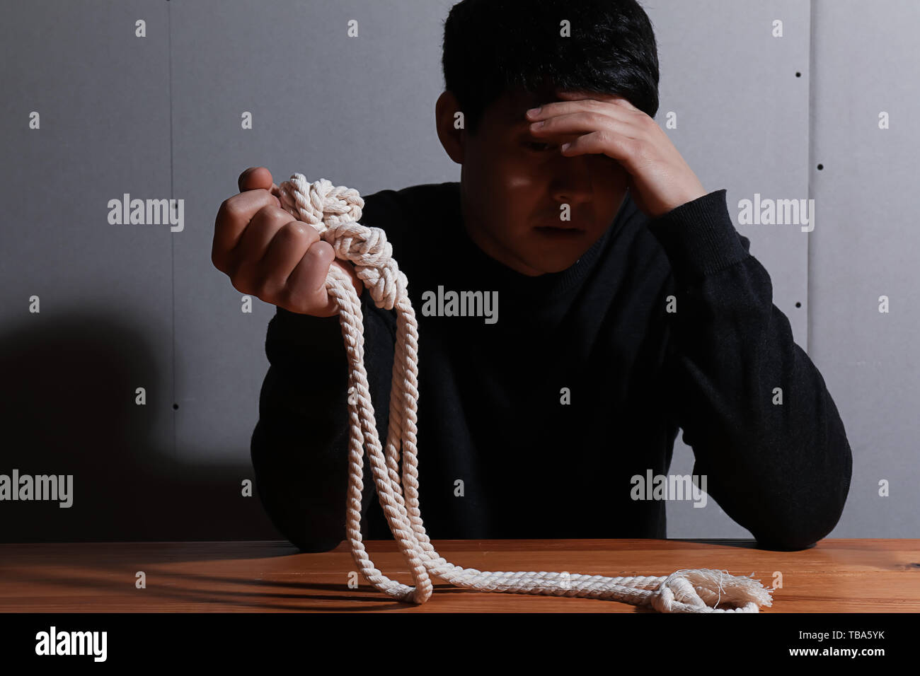 Depressed man with rope thinking about suicide at home Stock Photo - Alamy