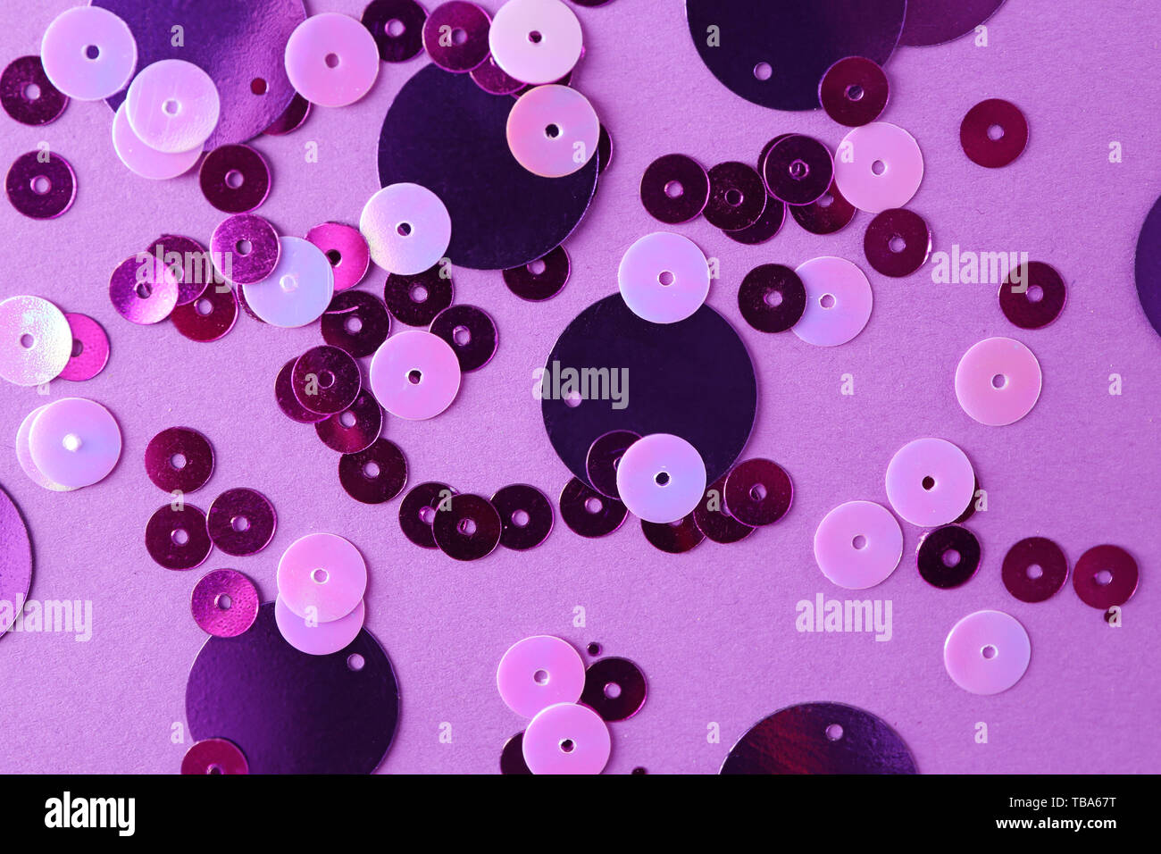 Different sequins on color background Stock Photo - Alamy