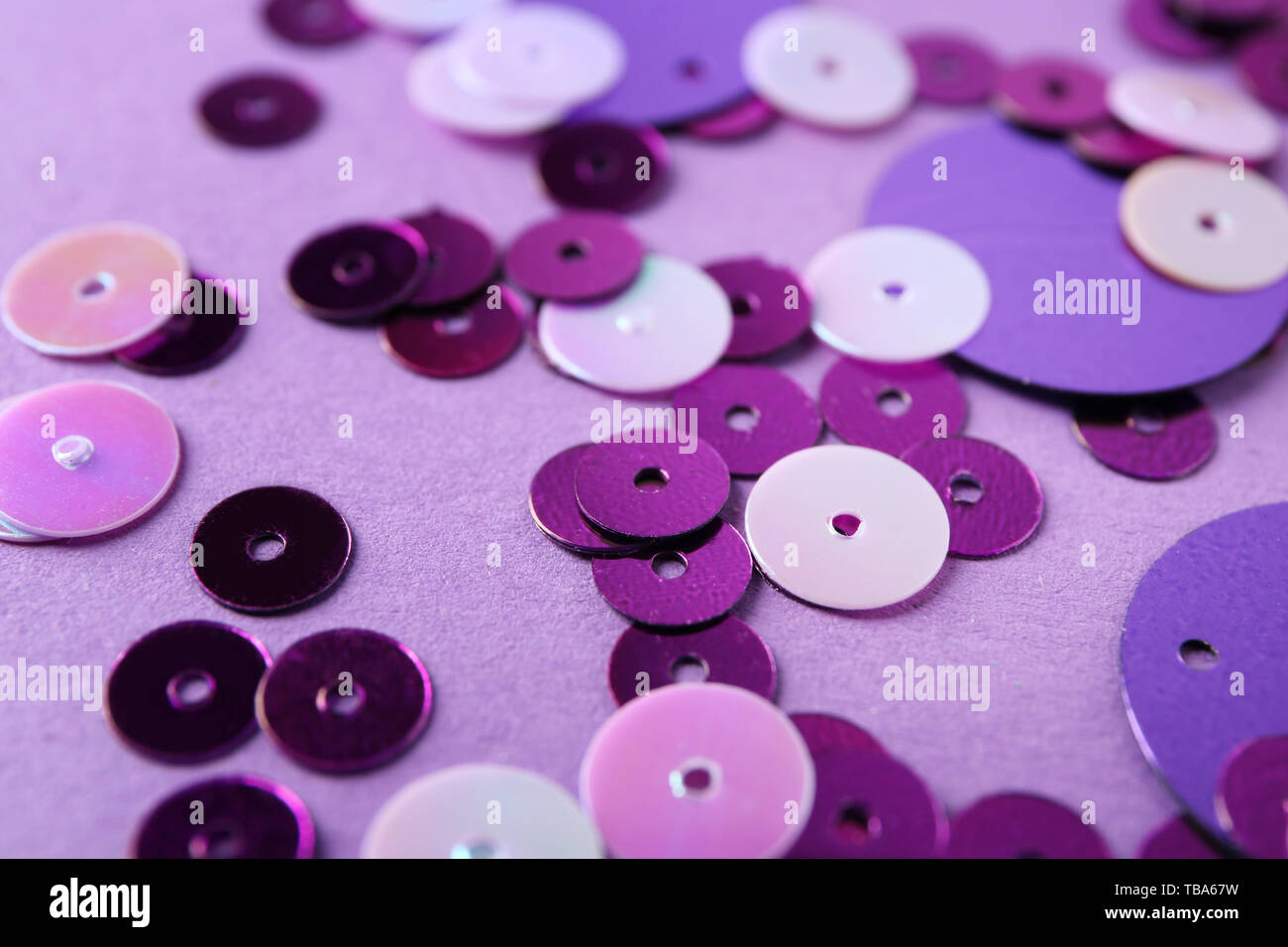 Different sequins on color background Stock Photo - Alamy