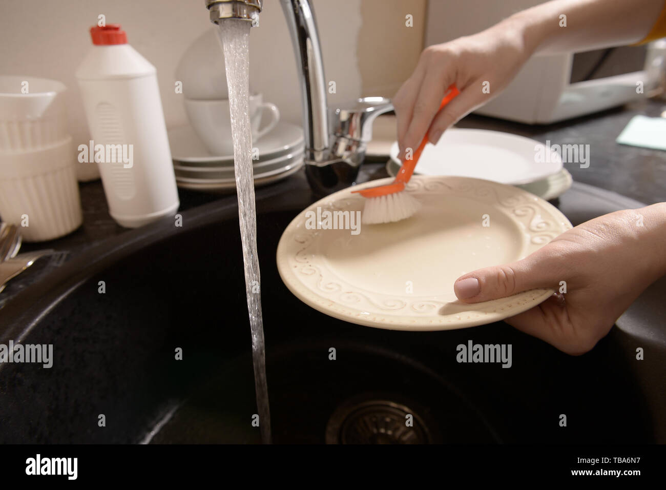 Woman washing dish hi-res stock photography and images - Alamy