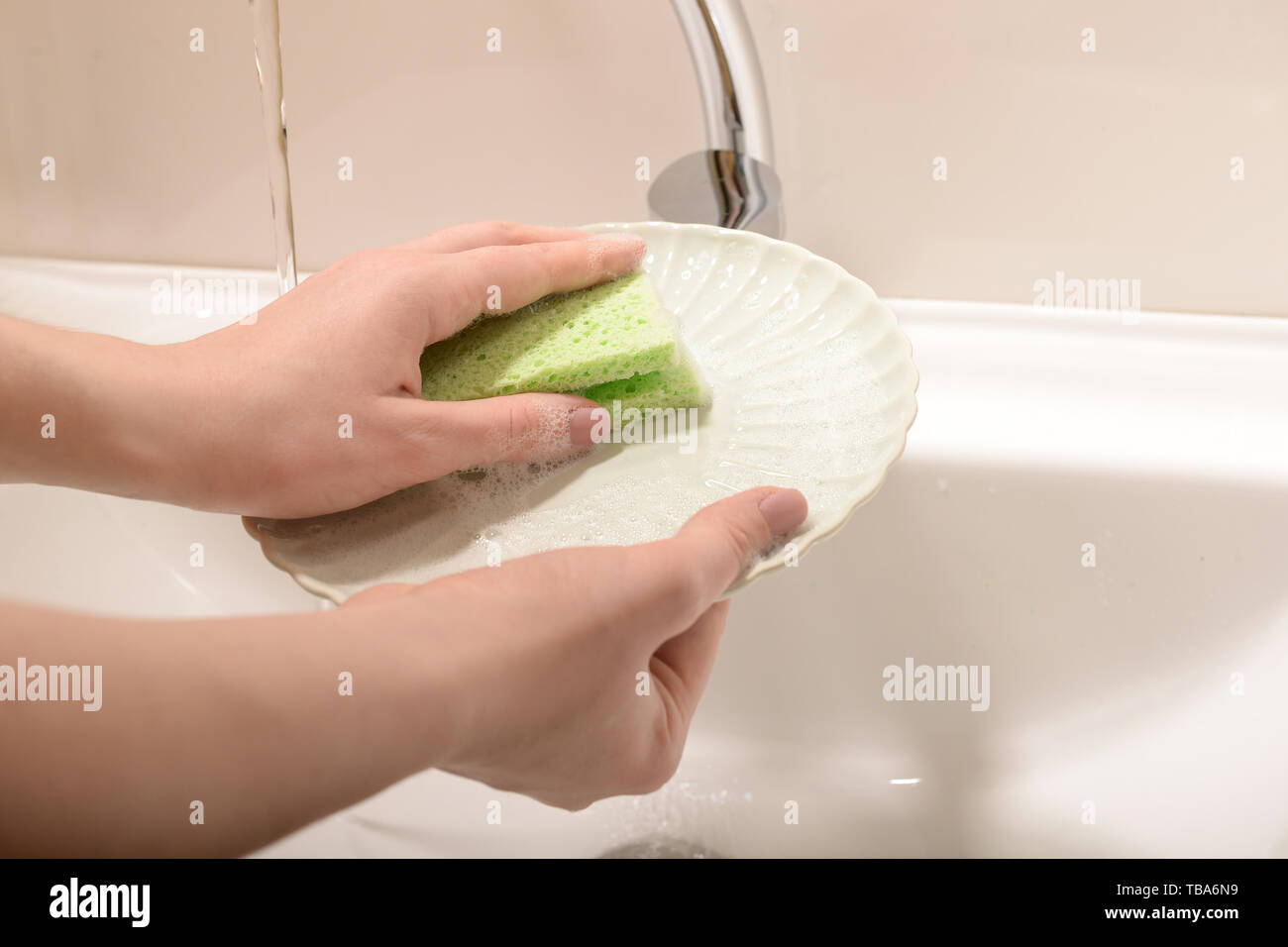 Woman washing dish in sink Stock Photo - Alamy