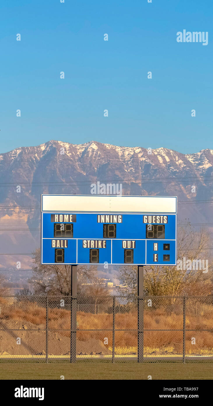 frame Vertical Blue and white baseball scoreboard above the chain link ...