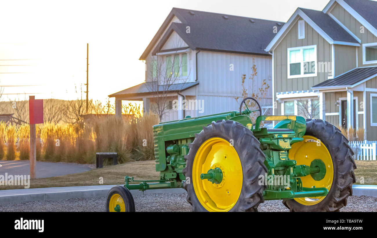 frame Panorama Replica of a tractor at a park with houses and sky in ...