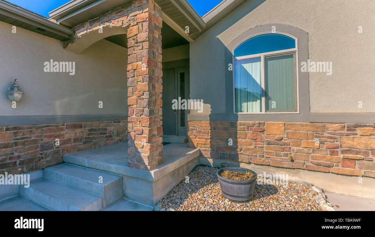 frame Panorama Facade of a home with a rocky yard and small front porch ...
