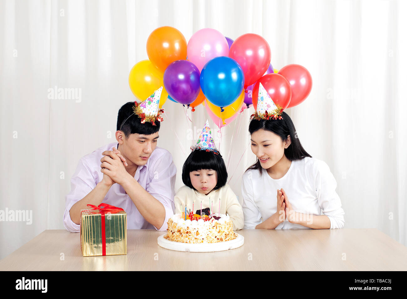 Parents celebrate daughter's birthday Stock Photo - Alamy