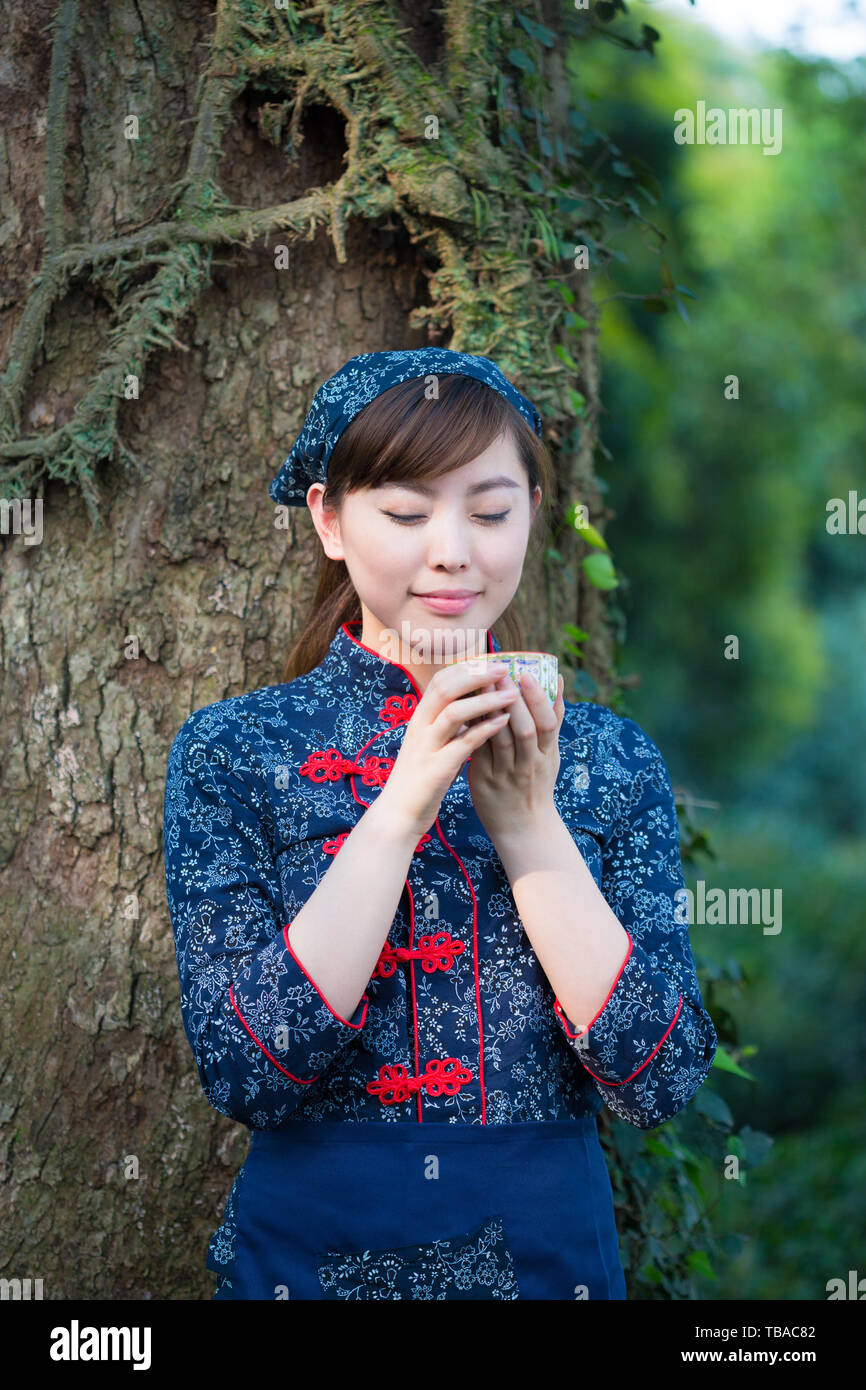 beautiful Asian girl holds cup in green tea plantation Stock Photo - Alamy