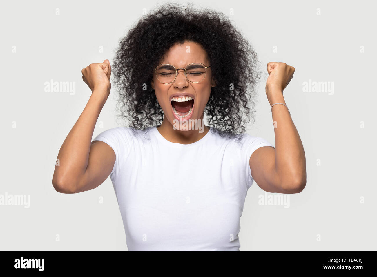 Happy cheerful excited african woman pose over grey background Stock ...