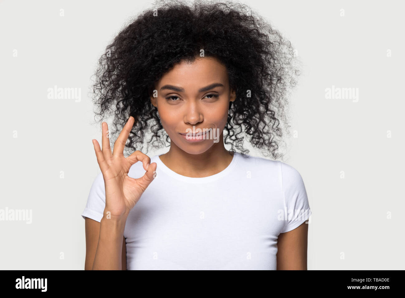 Happy african female showing ok sign pose over gray blank Stock Photo ...