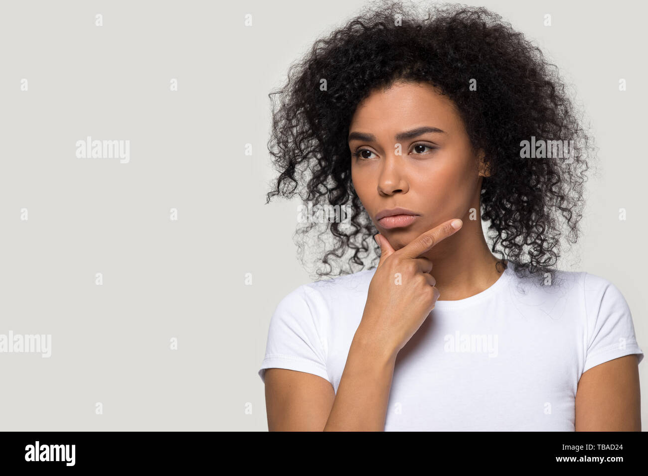 Thoughtful african woman thinking pose on grey wall looking aside Stock ...