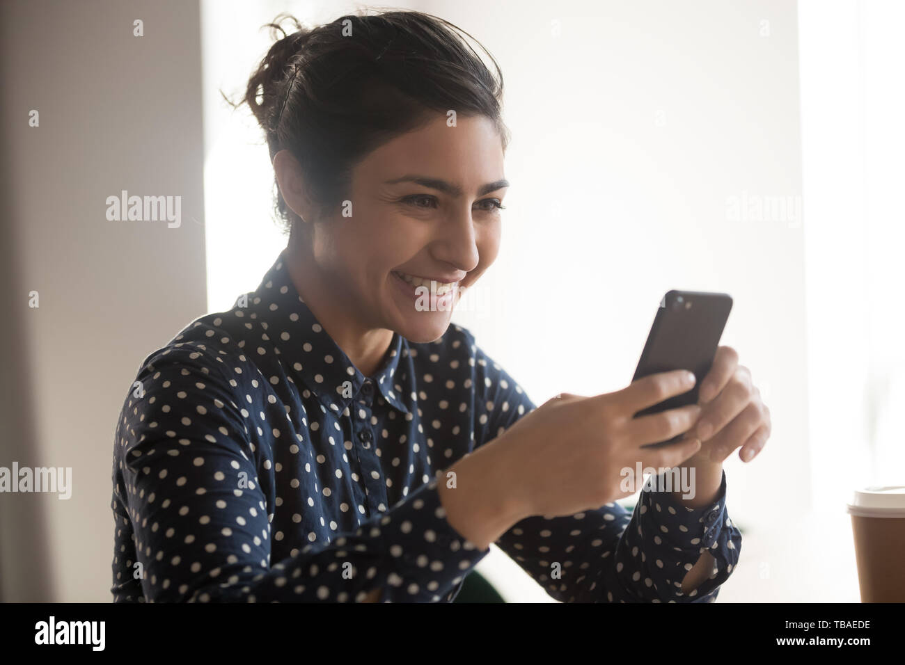 Close up of smiling indian woman typing message on smartphone Stock ...