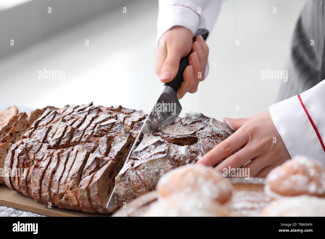 Female chef cut black bread hi-res stock photography and images - Alamy