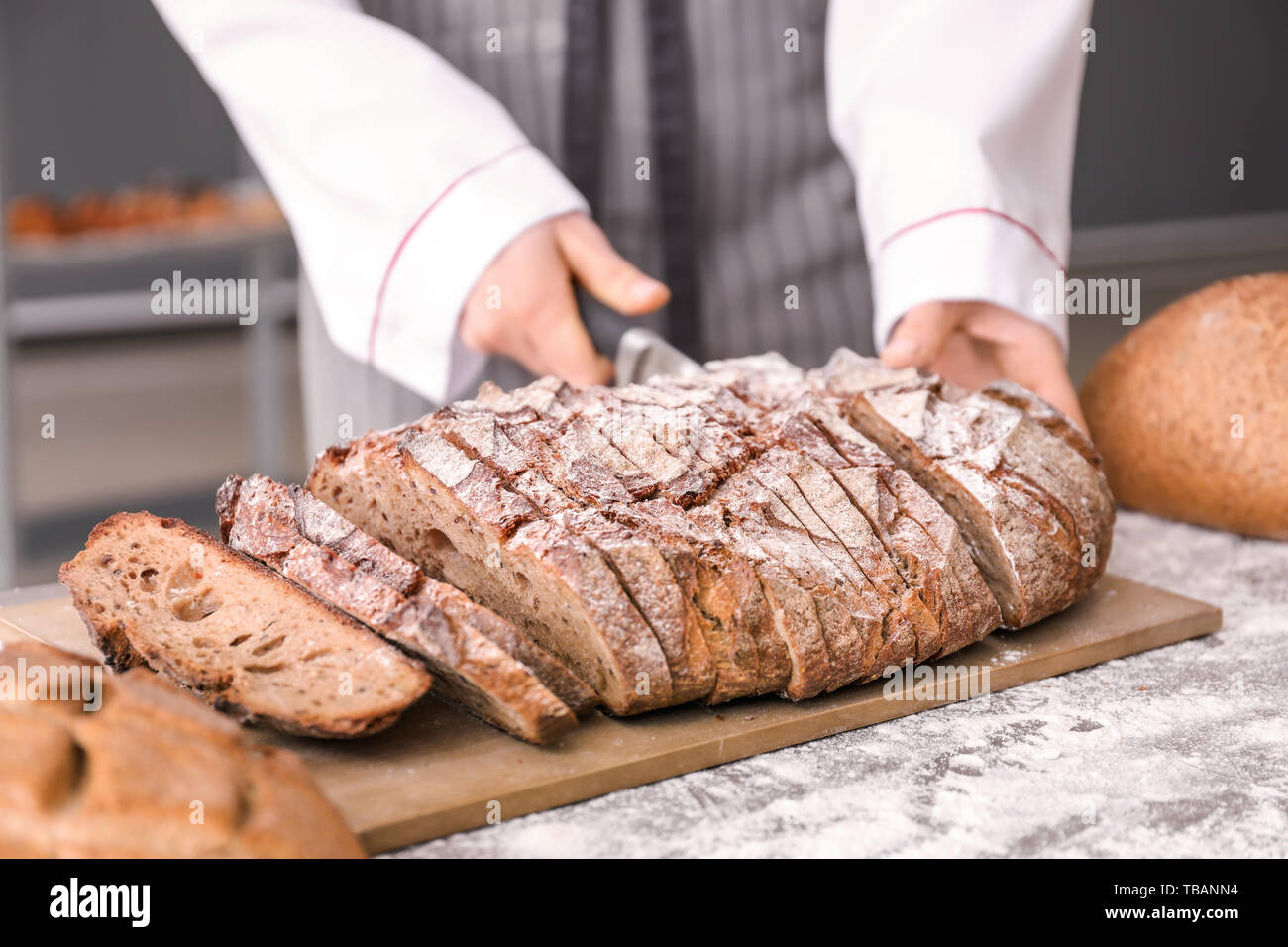 Female chef cut black bread hi-res stock photography and images - Alamy