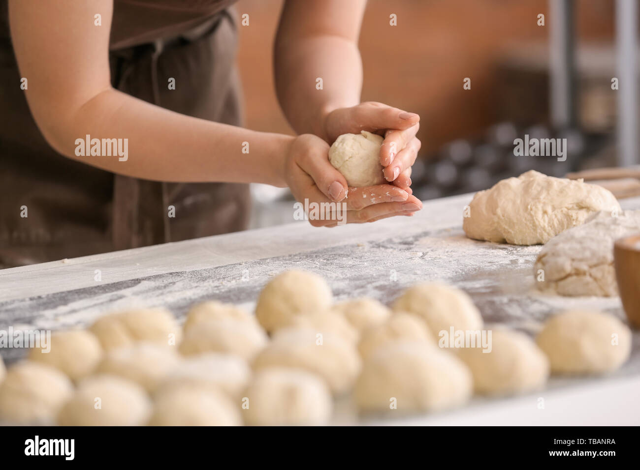 Female baker cooking buns in kitchen Stock Photo - Alamy