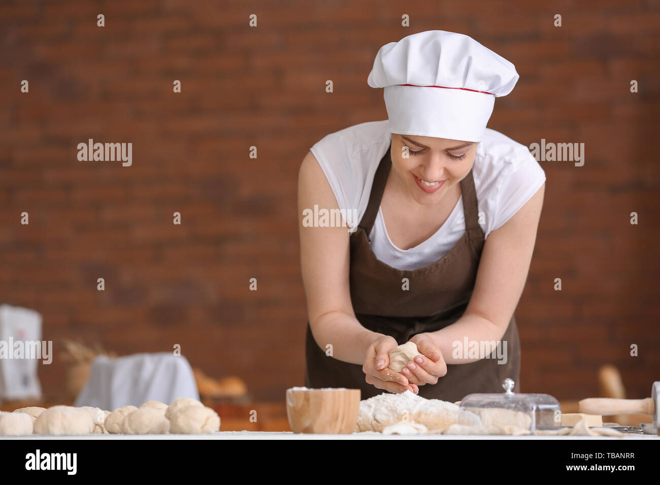 Female baker cooking buns in kitchen Stock Photo - Alamy
