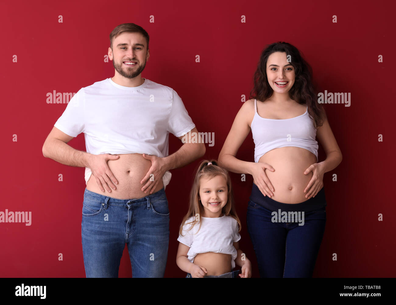 Happy family expecting baby on color background Stock Photo - Alamy