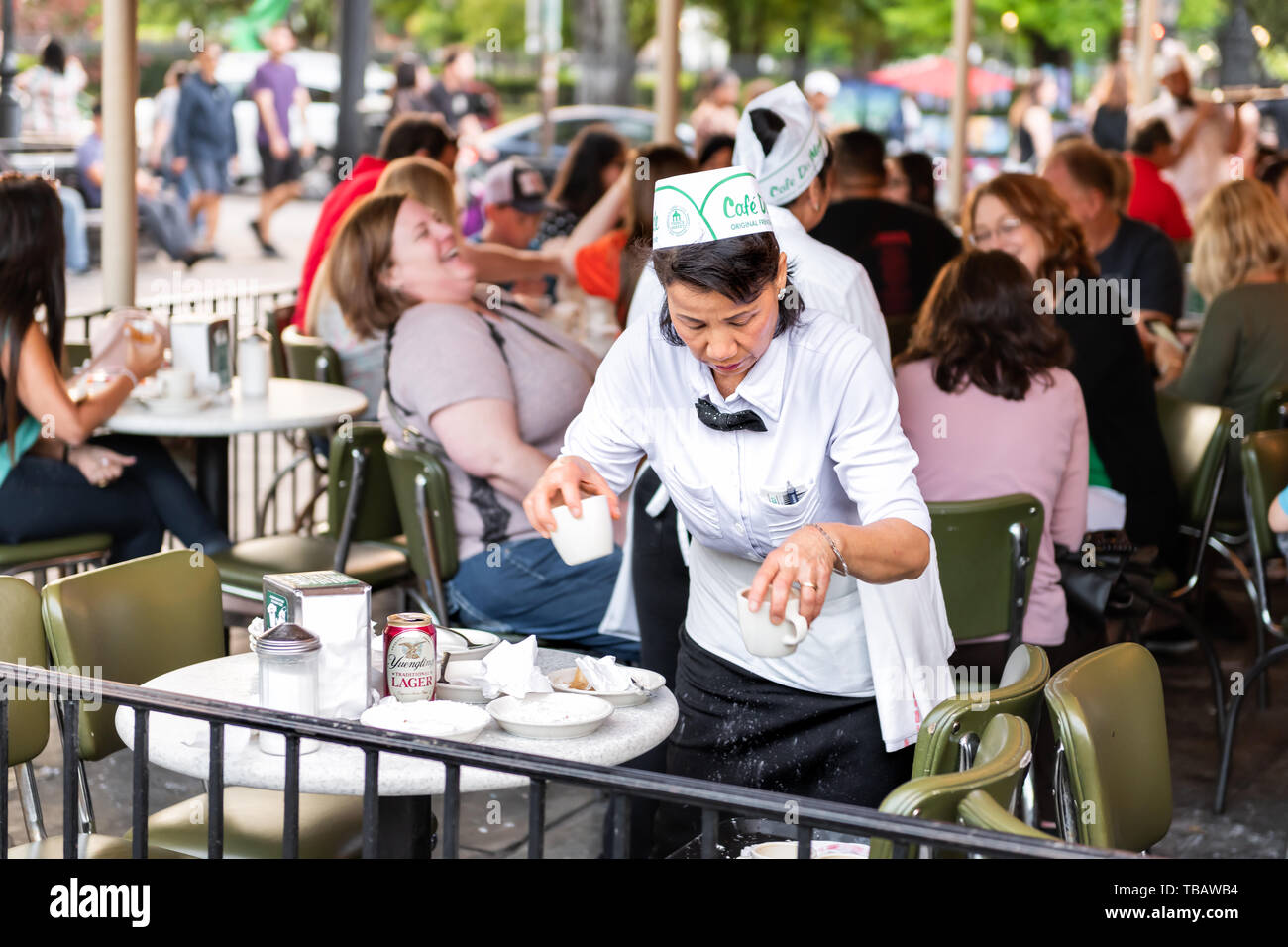 New Orleans, USA - April 23, 2018: Waitress woman cleaning up with ...