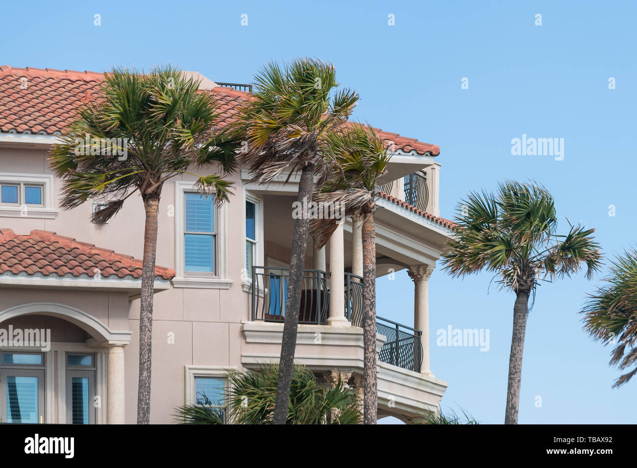 Closeup of colorful villa house or home with palm trees red tiles tiled ...