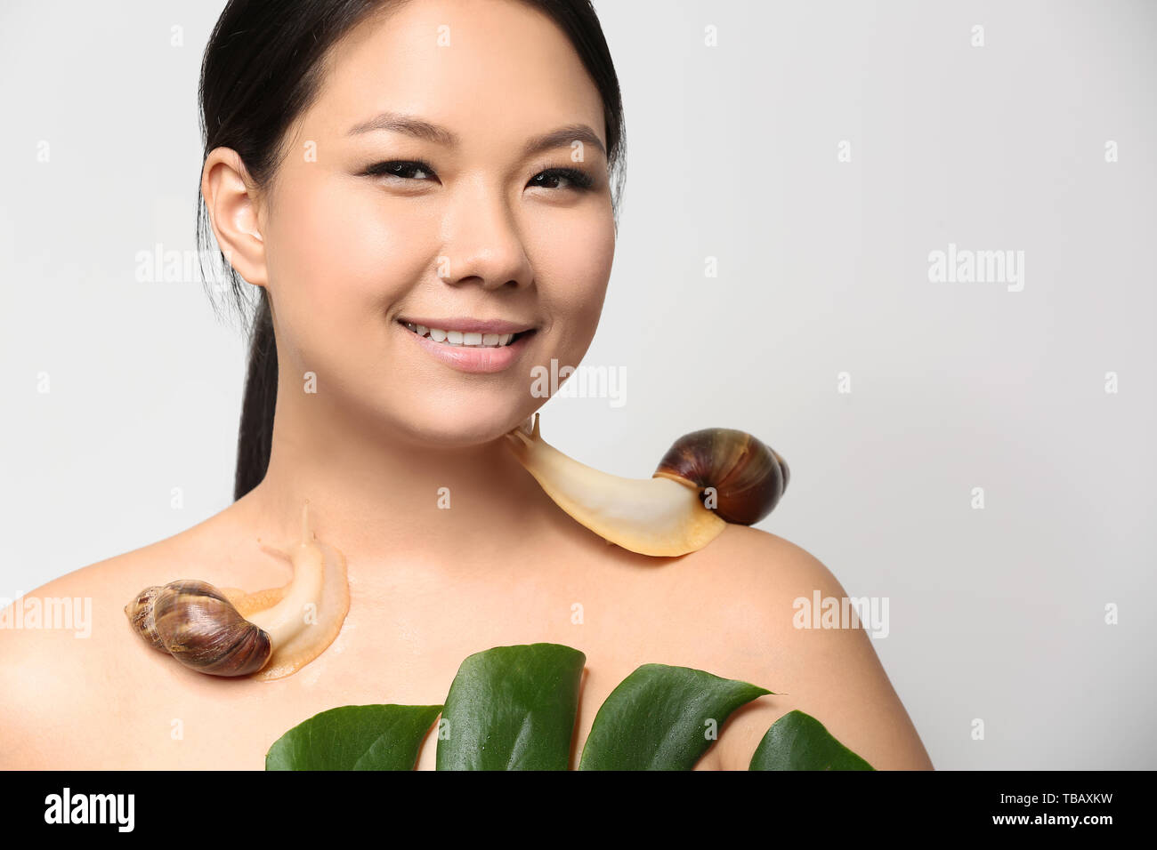 Asian woman with giant Achatina snails on white background Stock Photo ...