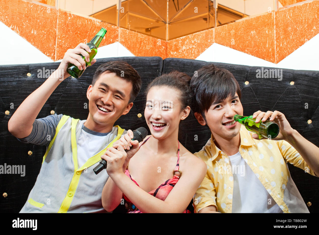 Three friends sing at KTV party Stock Photo - Alamy