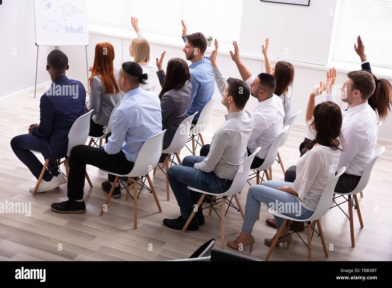 Multi Ethnic Business People Sitting On Chair In Row Raising Their Arms ...