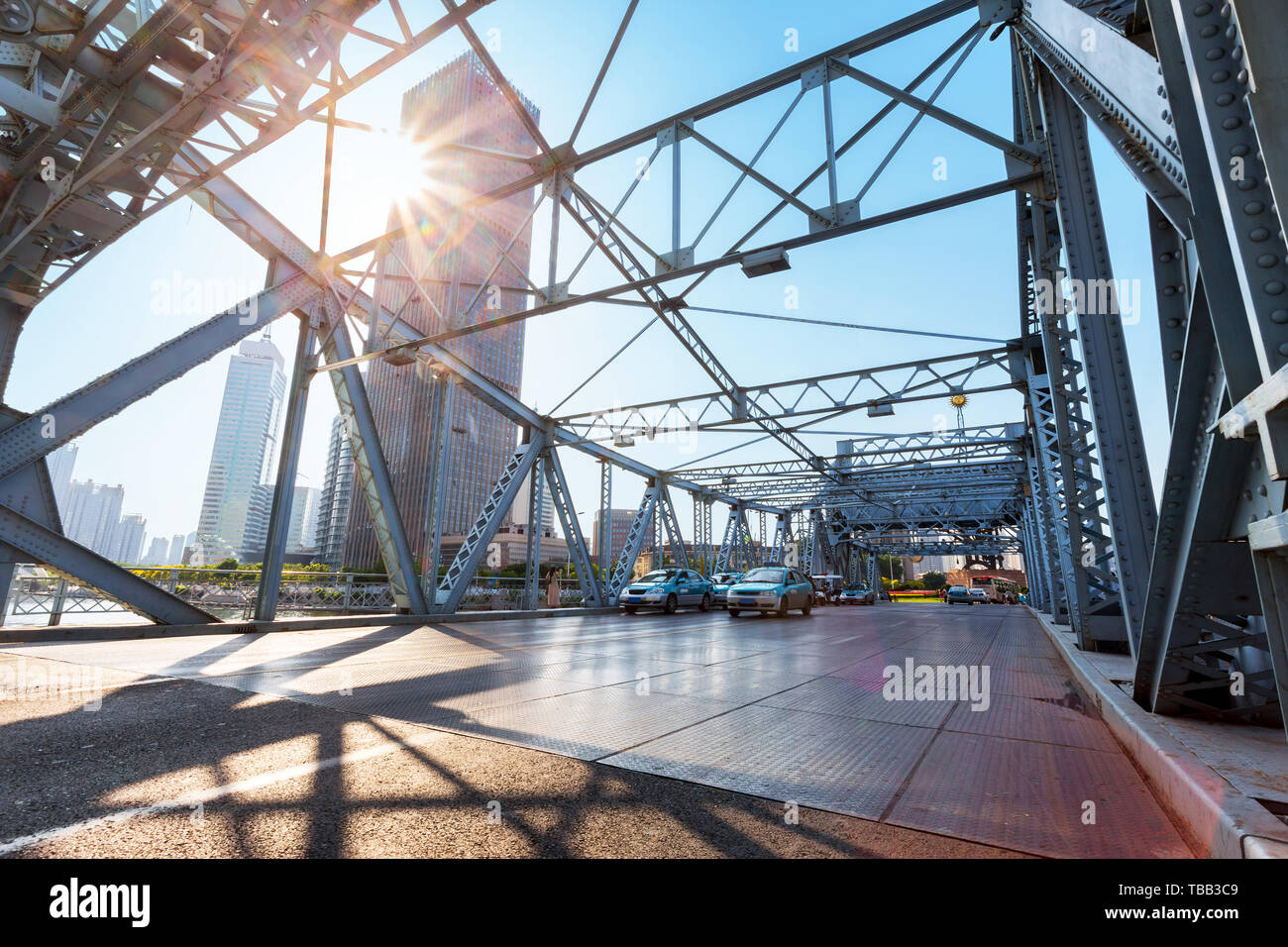 Traffic on steel bridge interior and skyline at sunset Stock Photo - Alamy